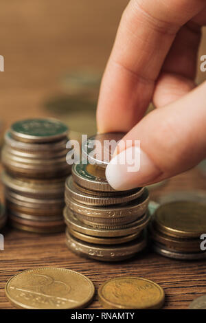 woman put coins to stack of coins Stock Photo - Alamy