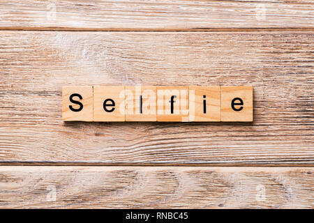 selfie word written on wood block. selfie text on cement table for your ...