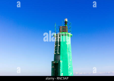 A green lighthouse in Denia, Spain. The blue sky is in the background ...