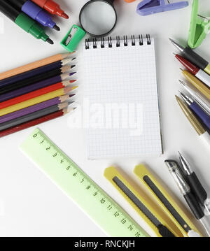 Blank notebook, binder clips, eraser and sharpeners on dark background ...