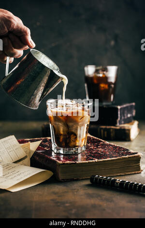 Pouring milk into glass cup and beans at wooden table, closeup Stock ...
