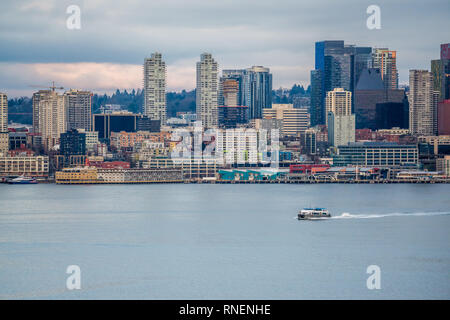 A boat cruises across Elliott Bay in front of the Seattle skyline Stock ...