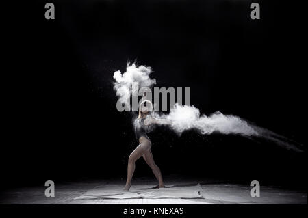 Girl dancing with a flour on black background Stock Photo - Alamy