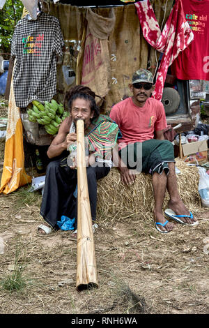 Man playing a didgeridoo musical instrument in a store in Cairns city ...