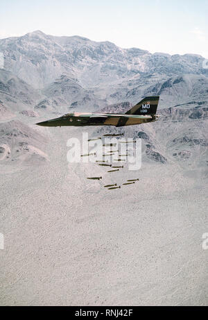 A left side view of an F-111A dropping 24 Mark 82 low-drag bombs in ...