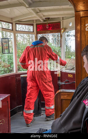 Engineer driving the heritage tram using the brake lever to control the ...