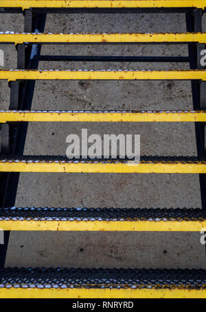 old concrete steps with yellow metal railings leading in to the ...