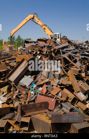 Material handler fitted with a magnet used to move a pile of ferous ...