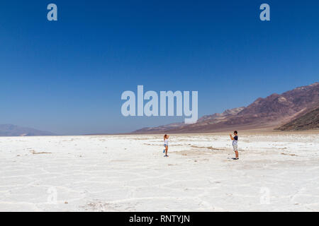 couple on salt flats, Badwater Basin, Death Valley National Park ...