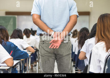 Teacher watching over students in elementary classroom Stock Photo - Alamy