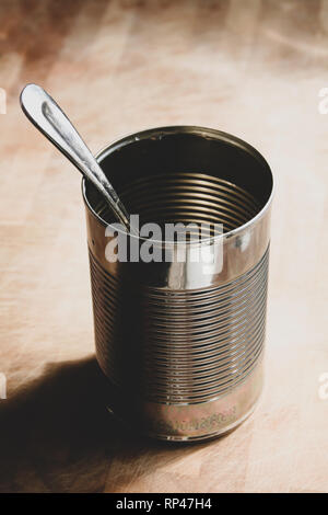 Empty canned food tin with spoon over white background - unhealthy ...