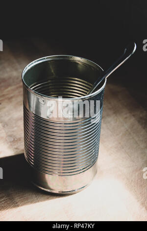 Empty canned food tin with spoon over white background - unhealthy ...