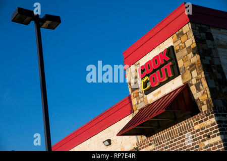 A logo sign outside of a Cook Out fast food restaurant location in ...
