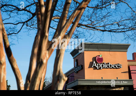 A logo sign outside of a Applebee's restaurant location in ...