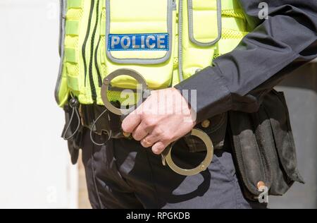 Portrait of a uniformed police officer holding handcuffs Stock Photo ...