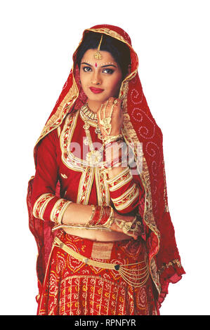 Rural Indian village bride dressed in colourful sari and gold jewelry ...
