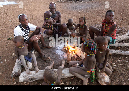 People from Zemba tribe sitting around fire in a traditional village ...