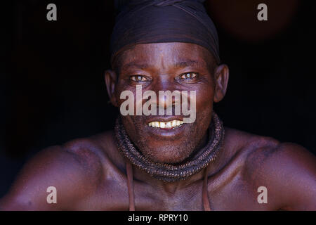 A chief of an indigenous Himba people tribe and his wife are posing in ...