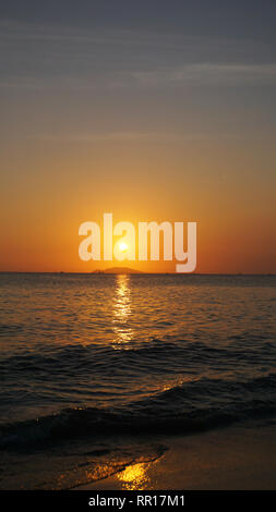 dramatic sky at sunrise with yellow colors with trees at the bottom ...