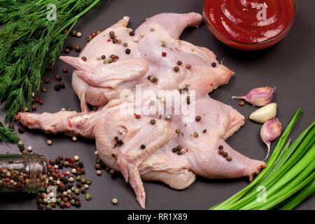 raw chicken carcass with peppercorns and greenery on a dark background ...