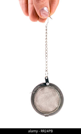 Tea strainer in hand close-up on a light background Stock Photo - Alamy