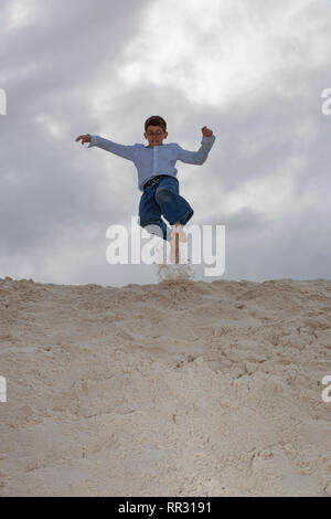 Boy jumping in sand dune Stock Photo - Alamy