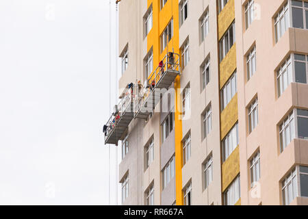 Builders paint the facade of a high-rise residential building Stock ...