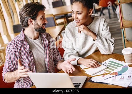 Attractive colleagues looking over ideas in co working space Stock ...