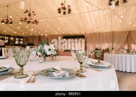 Lunch table for guests at a wedding. Fresh flowers in a vase on a table ...
