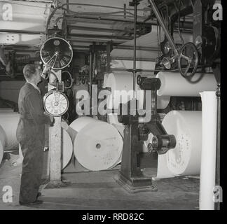 1950s, inside the Brittains paper mill at Cheddleton, England, a male ...