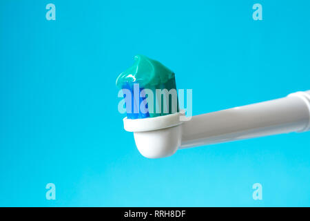 Electric toothbrush with green toothpaste with mint flavor close up on ...