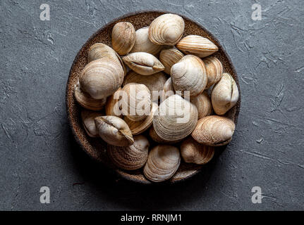 Fresh clams in textured white bowl on marble surface. Seashells, red ...