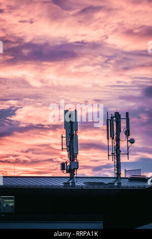Transmitter antennas in the evening. Orange sky and clouds Stock Photo ...