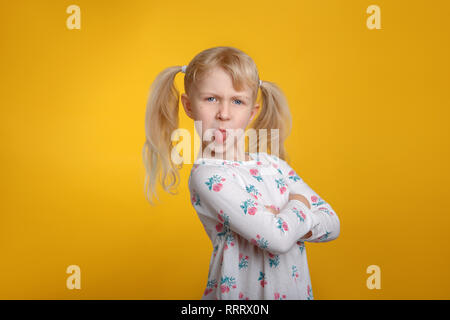 Unhappy preschooler girl in white dress and straw hat on a street of ...