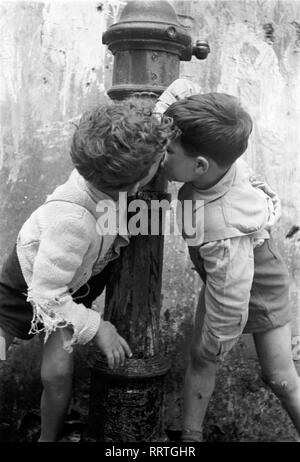 Children in Naples, Italy. Little boy helps one-legged companion across ...