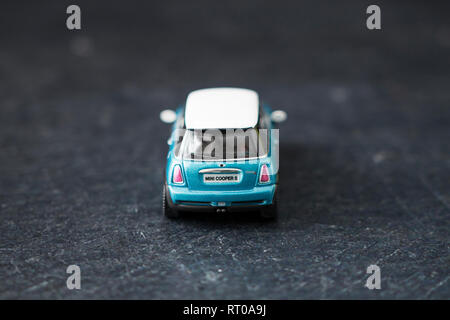 A toy teal blue Mini Cooper S metal car in macro photographs on a slate ...