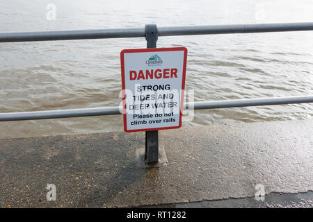 Warning sign for deep water and strong currents next to a lake in the ...