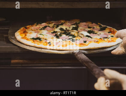 chef prepares delicious pizzas on the kitchen, view from the inside of ...
