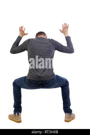 back view. man protects hands from what is falling from above. Man ...