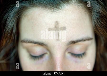 A close up of a cross of ashes on the forehead of a Roman Catholic man ...