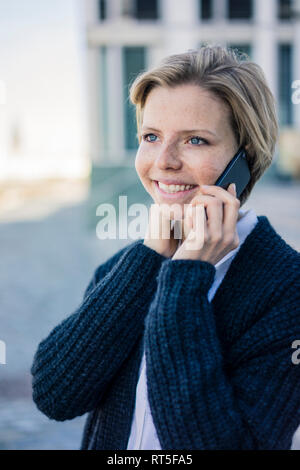 Young businesswoman with mobile phone in wheelchair on white background ...