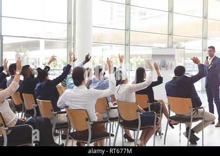Group of diverse business people raising their hands to ask questions ...