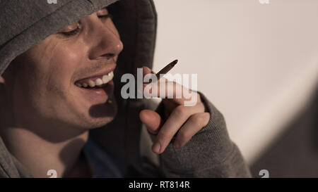 junkie man smoking and laughing under influence of narcotic Stock Photo ...