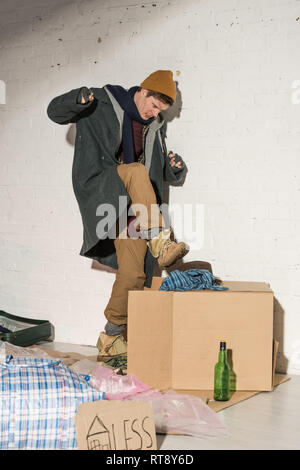 angry homeless man kicking cardboard box with garbage Stock Photo - Alamy
