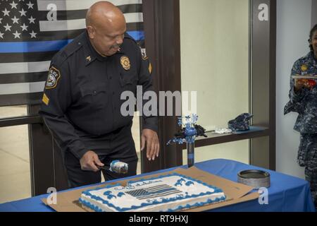 Naval District Washington Police Sgt. Ellery Bennett (center) receives ...