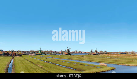Polder with canals and ditches with windmills along the river Zaan ...