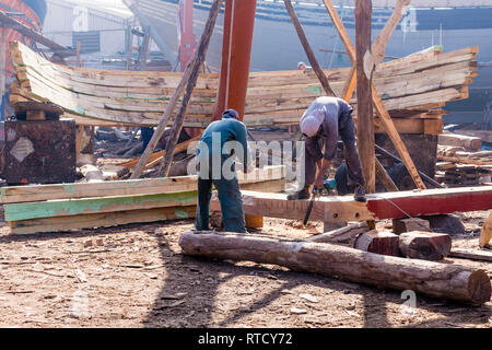 Shipwrights at work using simple tools to build wooden fishing boats by ...