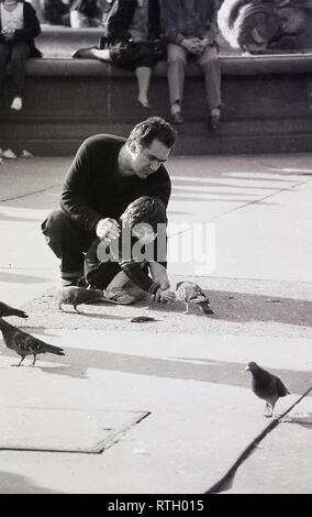 A man feeds a flock of pigeons in the Main Square in Krakow. On Monday ...