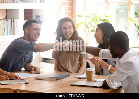 Multiracial group of friends giving fist bump together showing unity ...