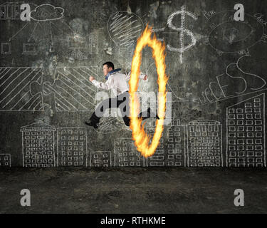A man is jumping through a ring of fire during the display of the Stock ...